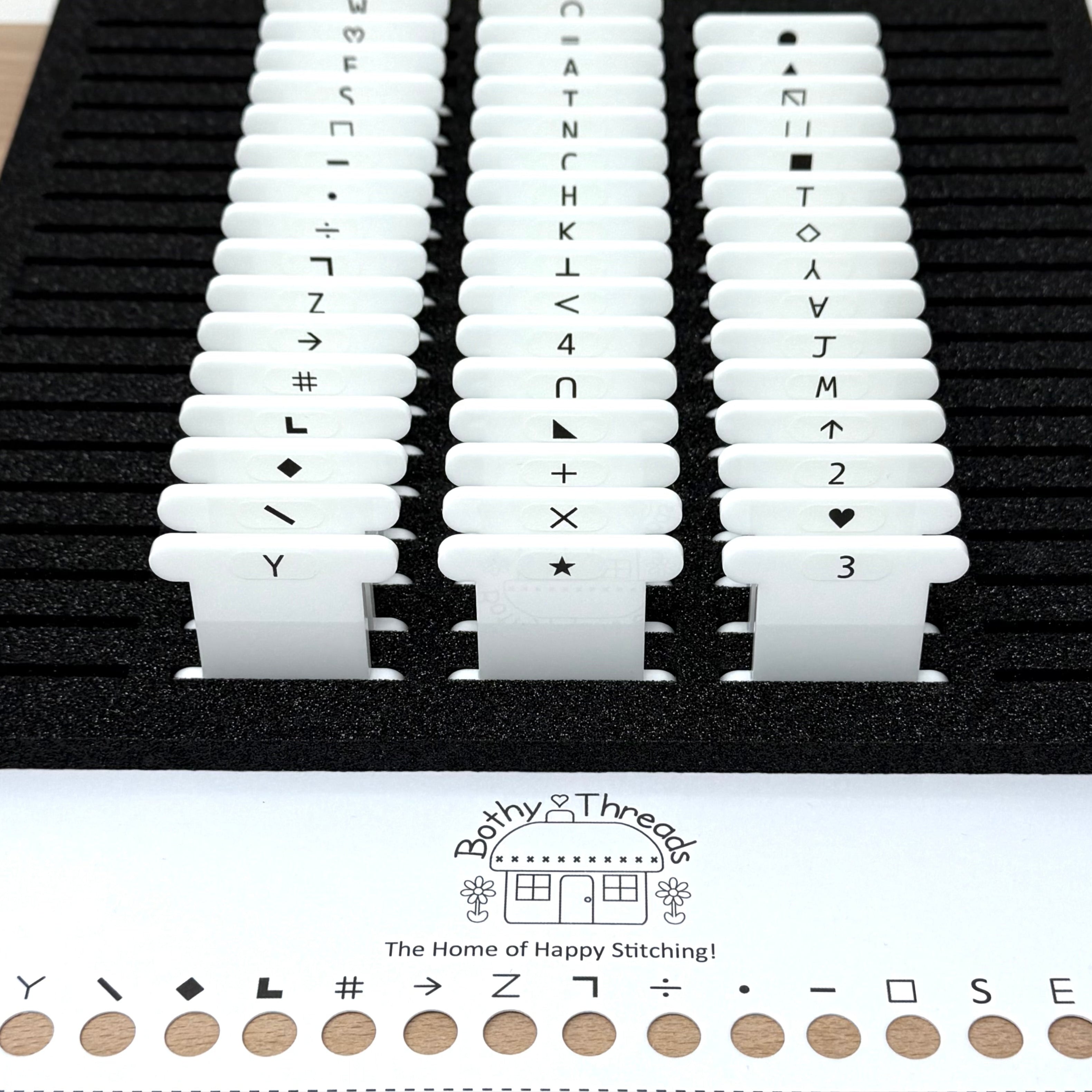 White acrylic bobbins with printed Bothy Threads Symbols (set of 47 bo ...